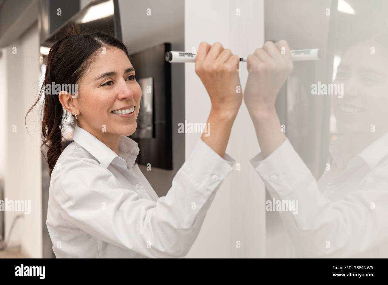Confident young woman explains her ideas to colleagues while writing on ...
