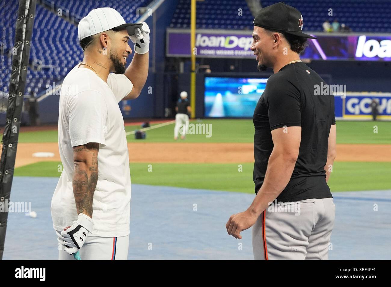 Miami Marlins' Victor Mesa Jr., left, talks with San Francisco Giants ...