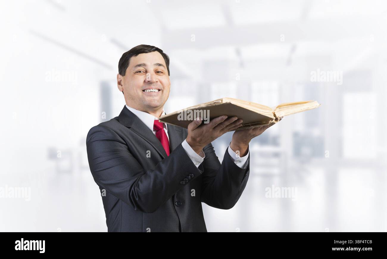 Happy senior businessman holding open book. Portrait of smiling adult ...