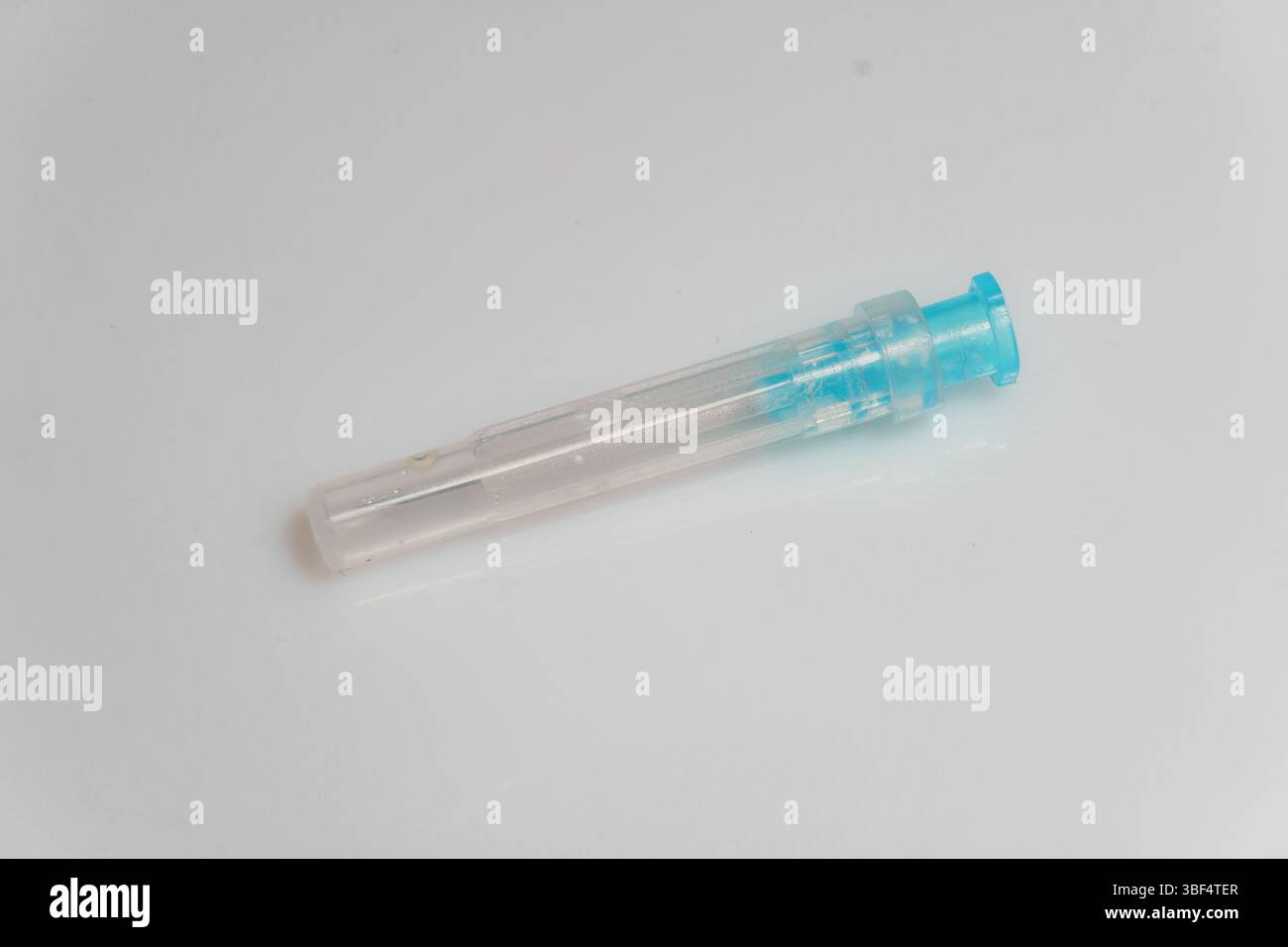 A close-up shot features a transparent medical hypodermic needle, a ...