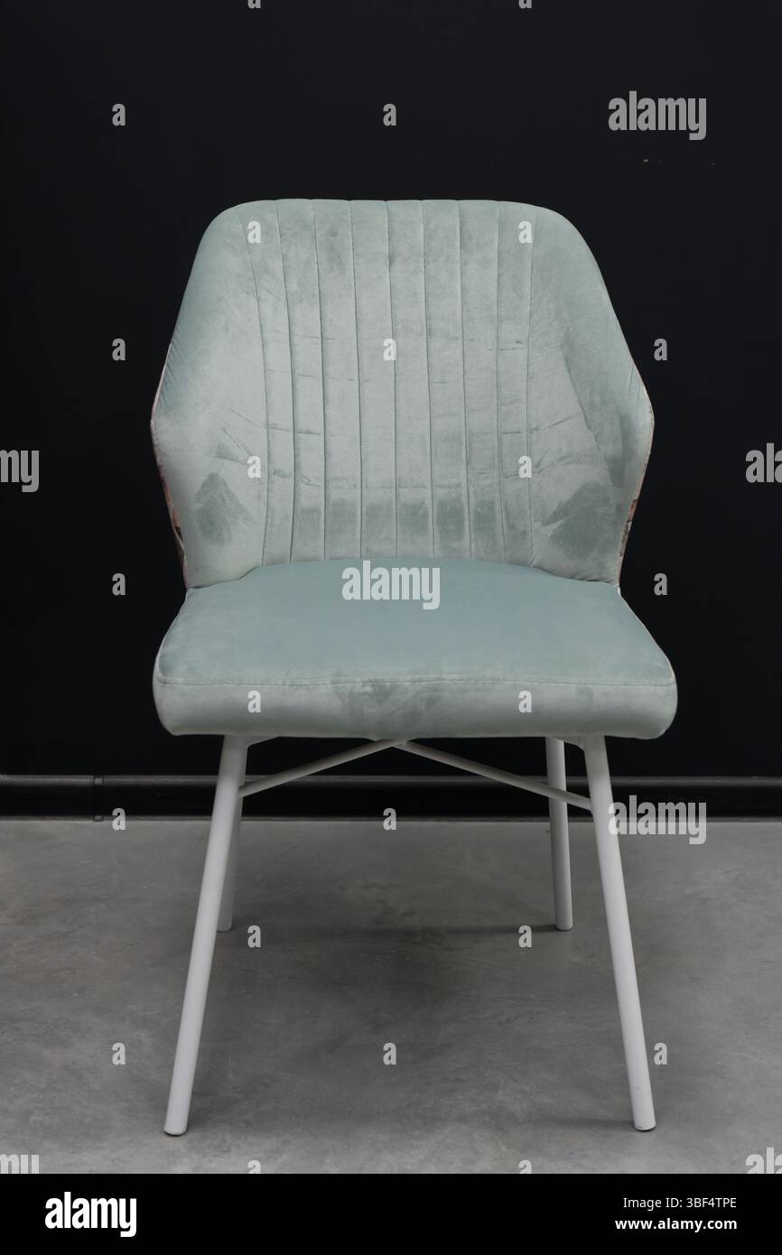 A beautifully upholstered mint green velvet dining chair with sleek ...