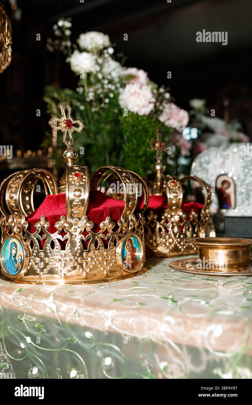 A beautifully arranged scene depicts golden Orthodox wedding crowns ...