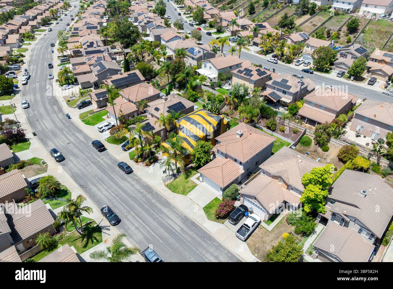 Aerial view of yellow and gray termite tent on a big house in San Diego ...