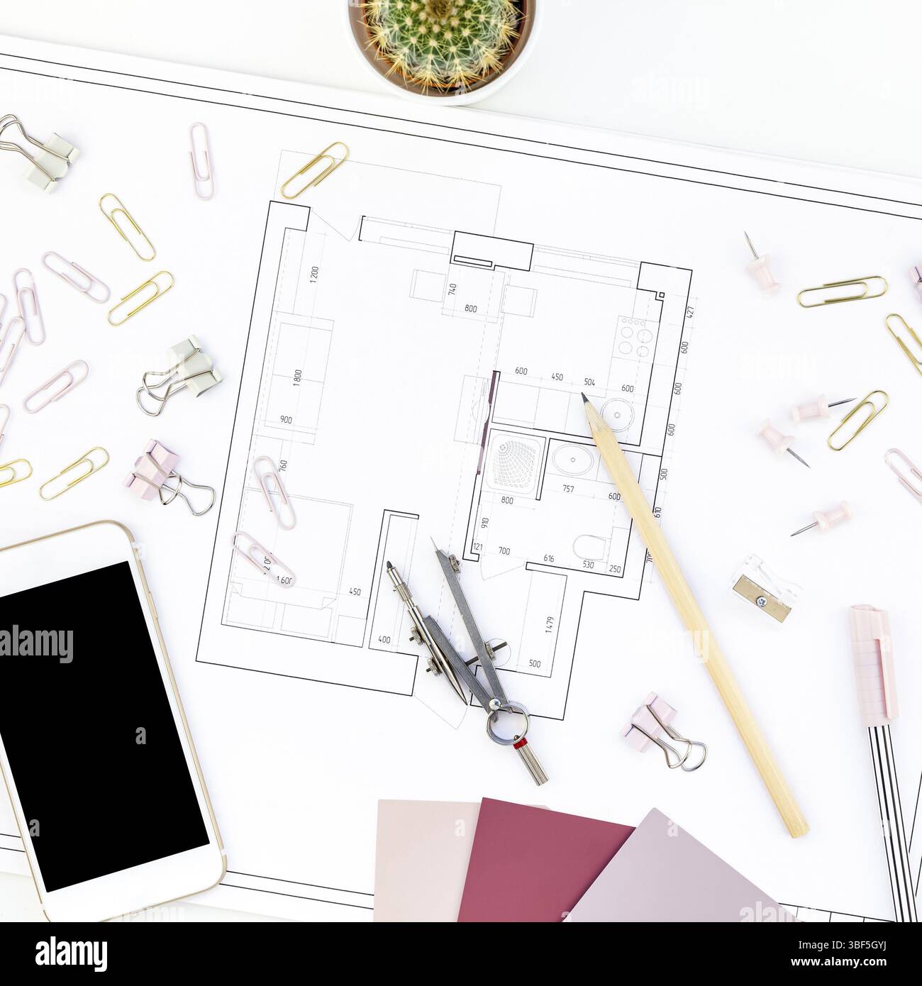 Blueprint flat project plan and office supplies on decorator table ...