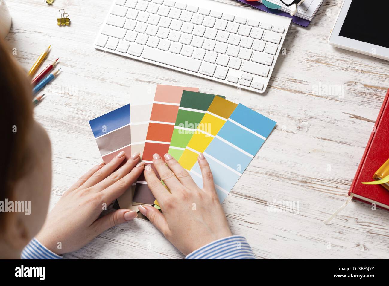 Interior designer choosing colors from swatches at wooden desk. Office ...