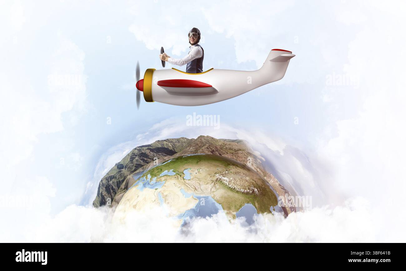 Happy pilot driving small propeller plane on background of blue sky ...