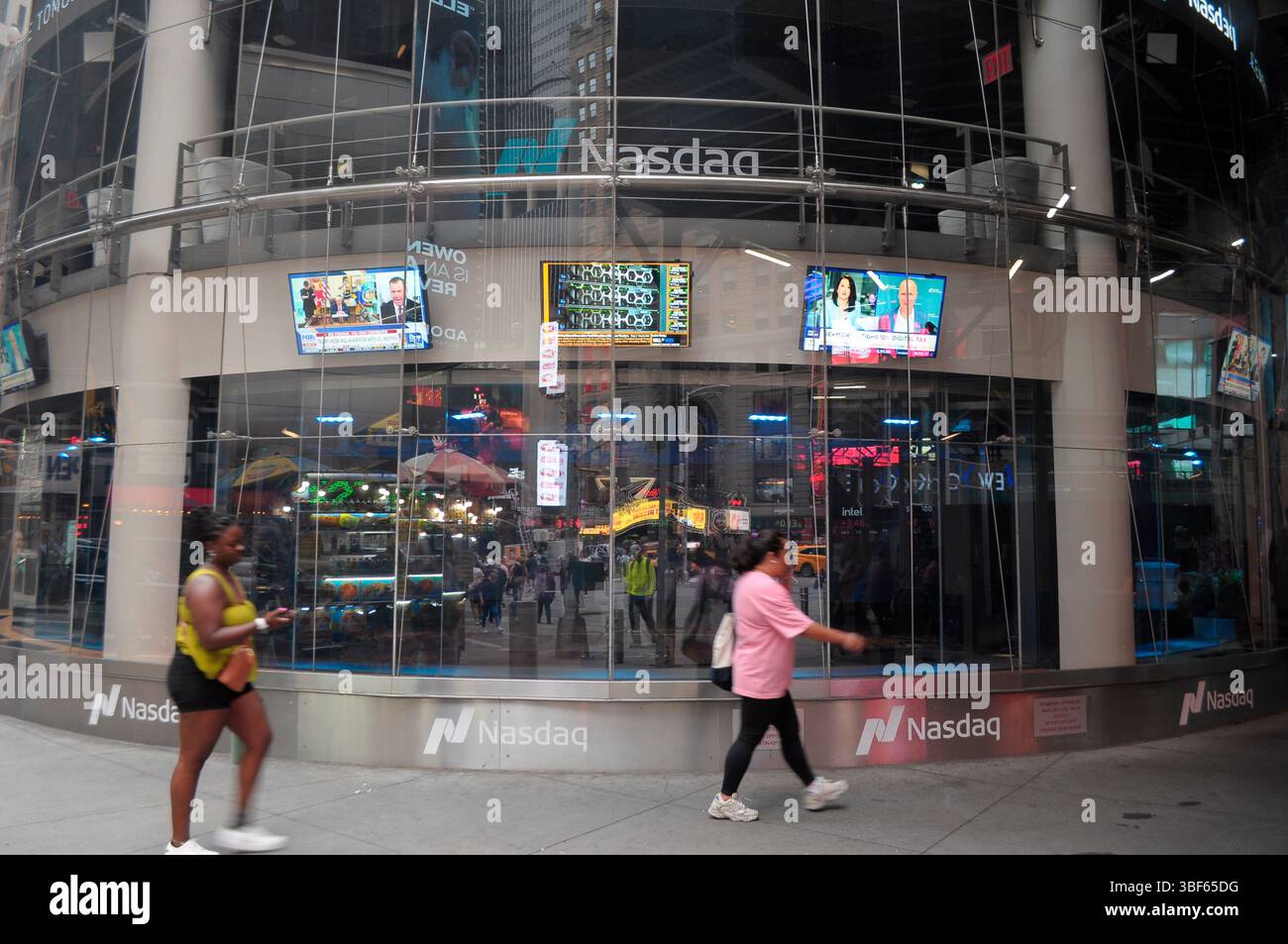 People walk past the Nasdaq MarketSite Times Square event space in ...