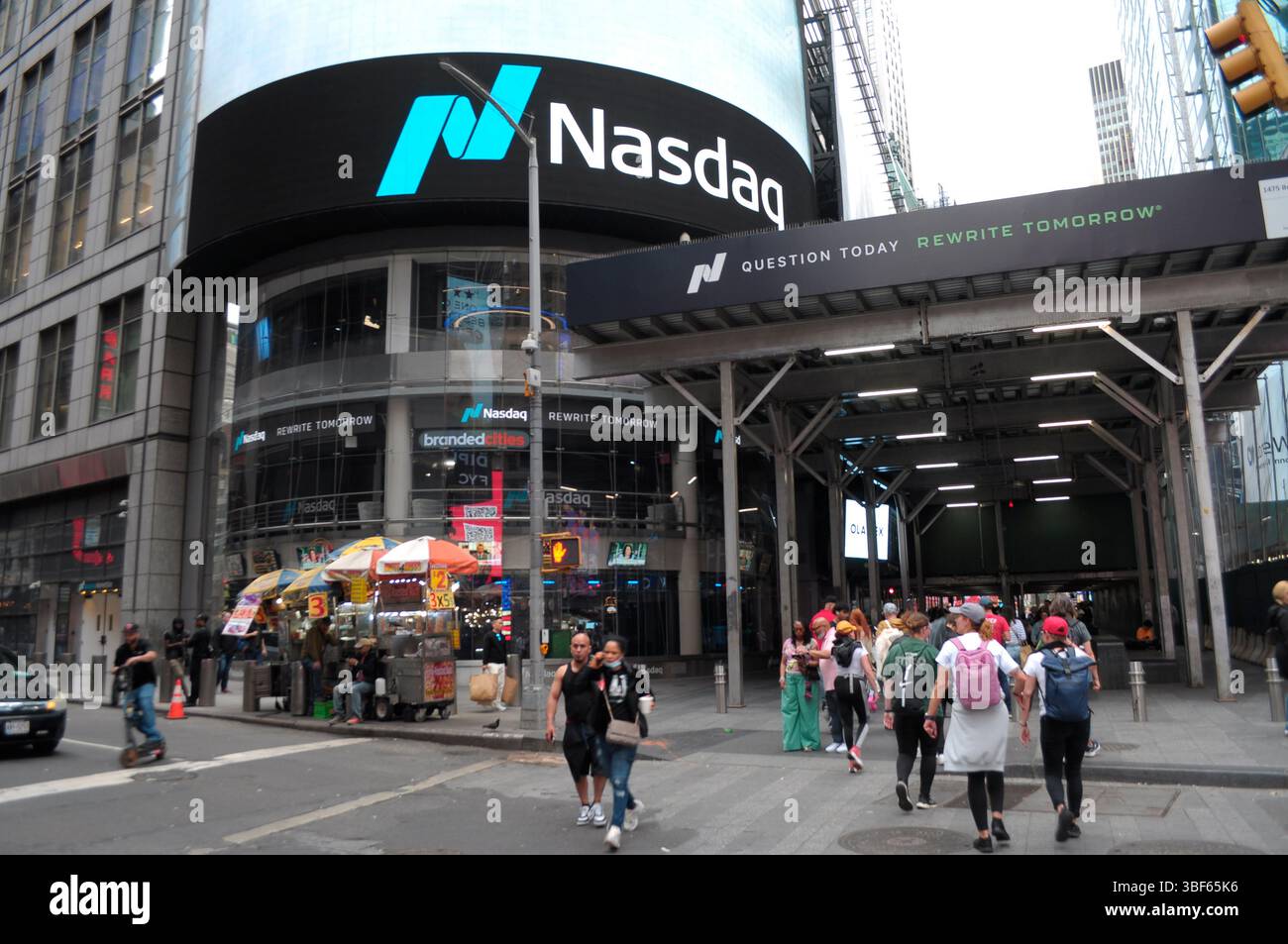New York, United States. 30th May, 2025. People walk past the Nasdaq ...