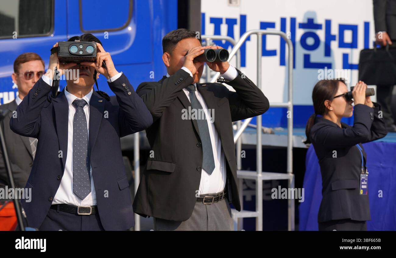 Security guards stand guard at a speech venue of Lee Jae-myung ...