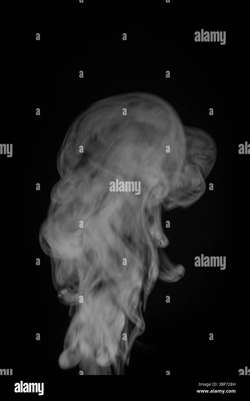 Wisps of ethereal smoke swirl gracefully against a dark background ...