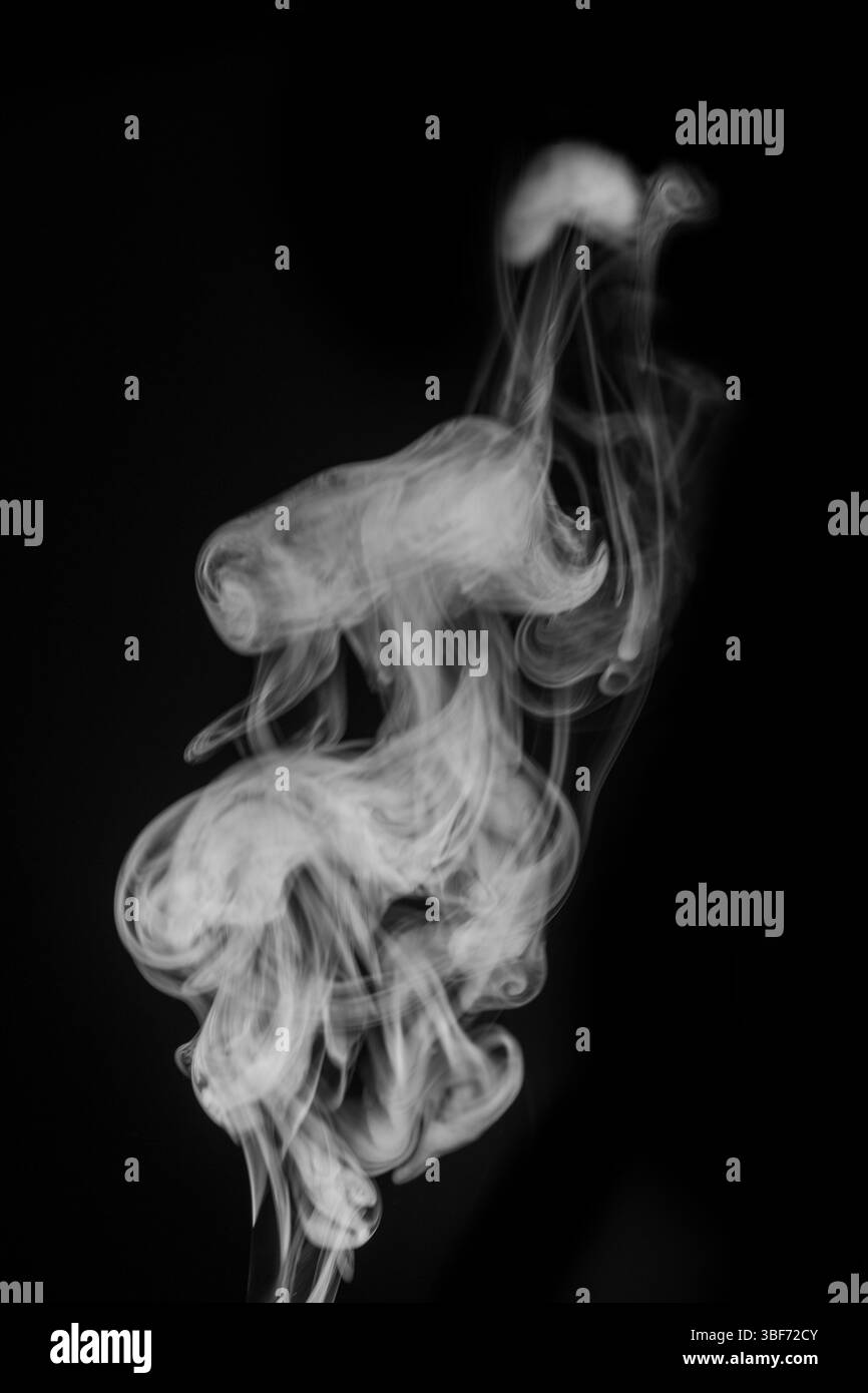 Wisps of ethereal smoke swirl gracefully against a dark background ...