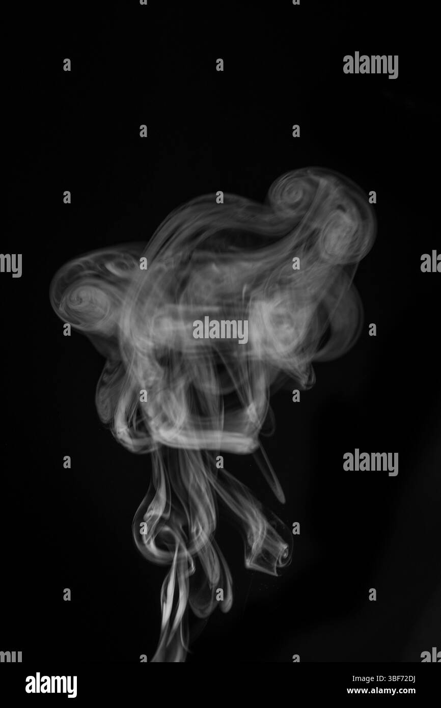 Wisps of ethereal smoke swirl gracefully against a dark background ...