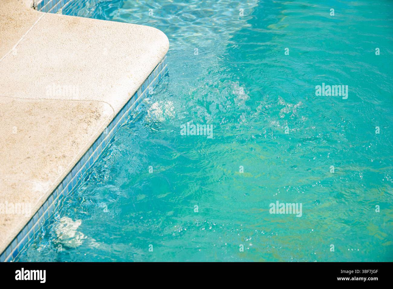 refreshing turquoise pool water splashing against stone edge, summer ...