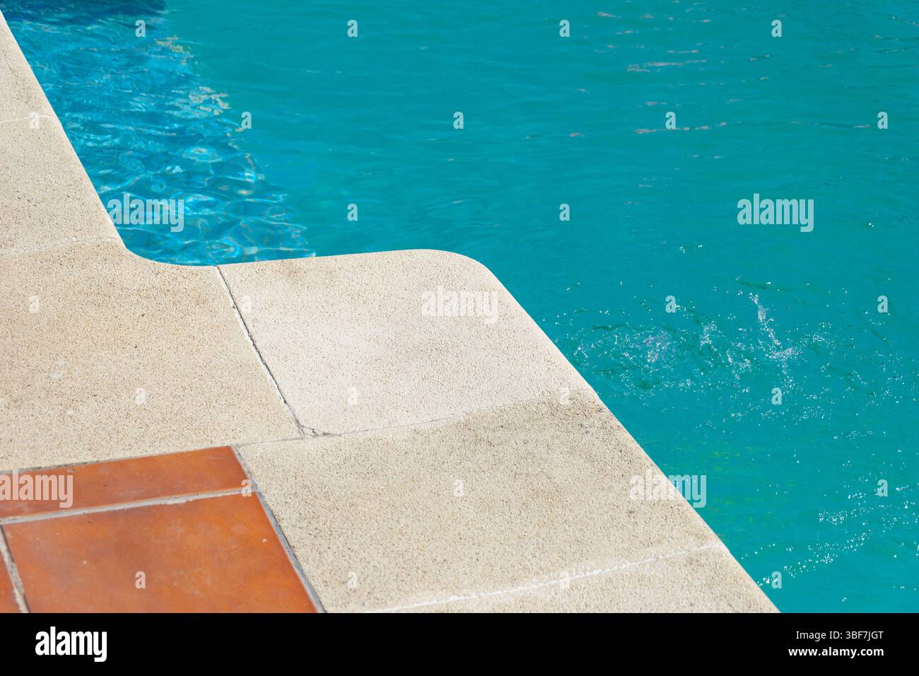 vibrant turquoise swimming pool water with elegant stone coping and ...