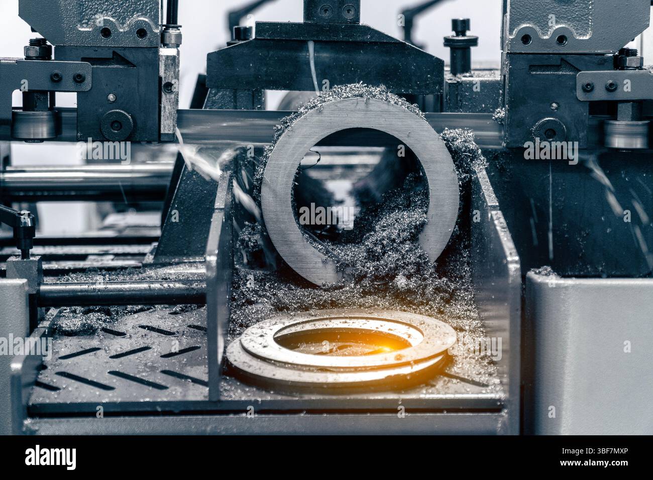 The band saw cutting machine cutting the metal shaft parts with coolant ...