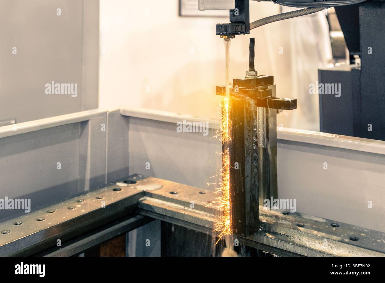 The wire-EDM machine cutting the die parts with the sparking light. The ...
