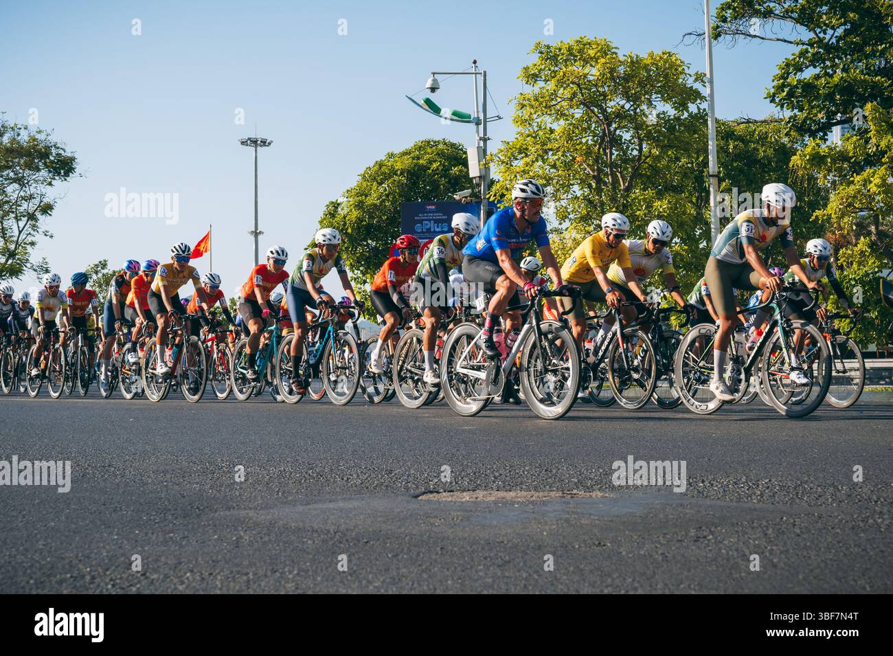 A group of Asian adult cyclists are cycling through Nha Trang city ...