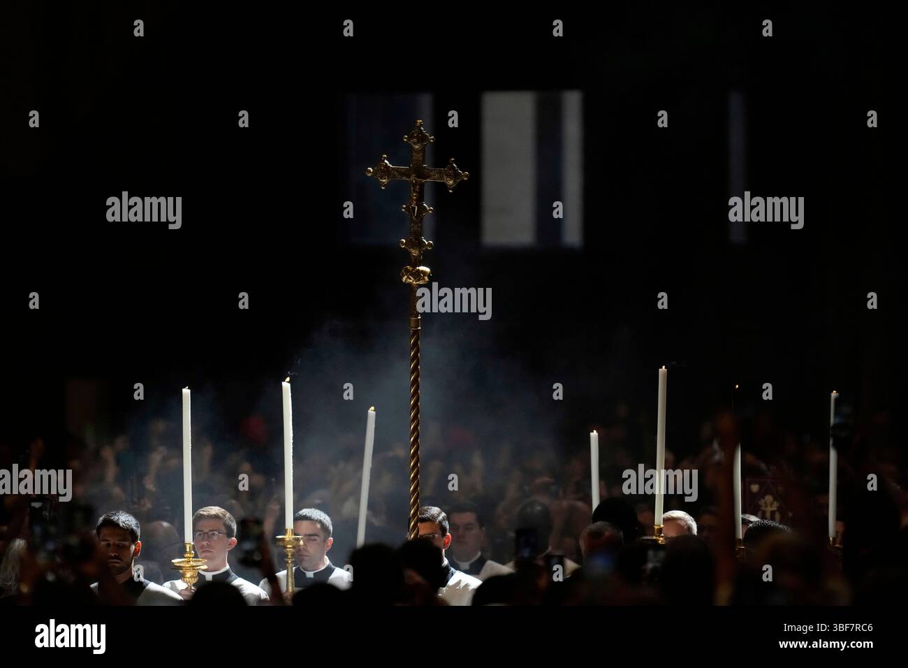 A cross is carried in procession prior to the start of a mass ...