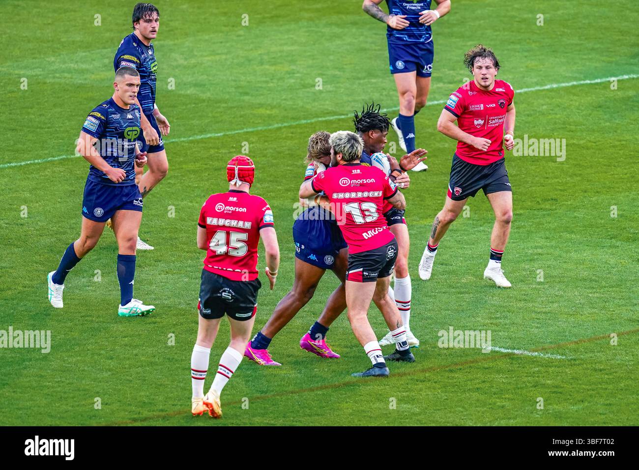SALFORD, ENGLAND - MAY 30: Junior Nsemba of Wigan Warriors is tackled by Joe Shorrocks of ...