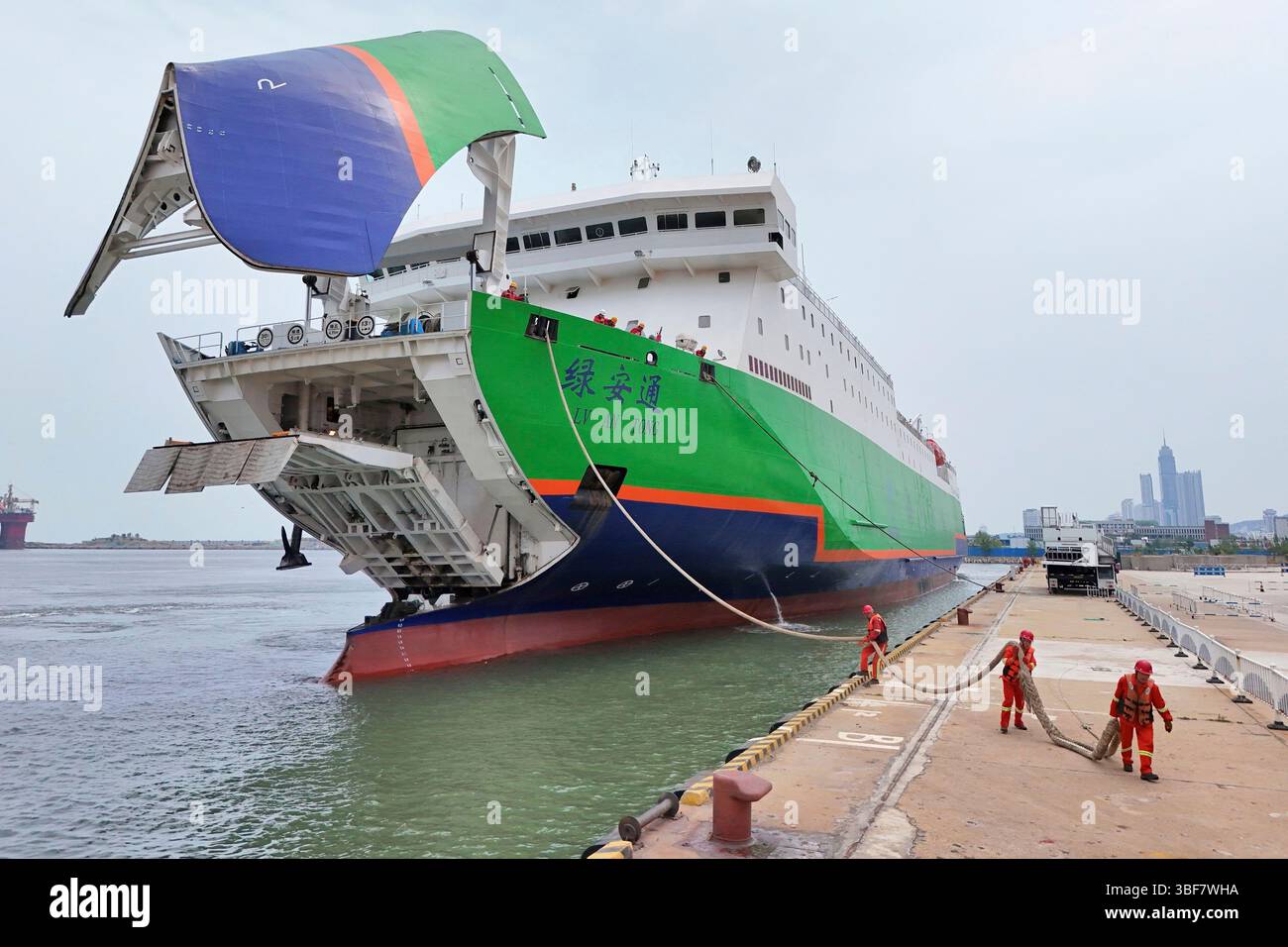 Port workers moor the ro-ro ship Lv An Tong to the dock in Yantai in ...