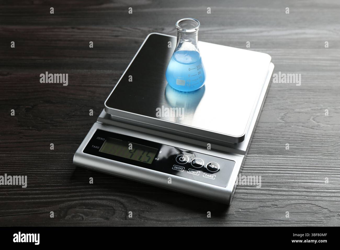 Laboratory scale with flask of sample on wooden table, closeup Stock ...