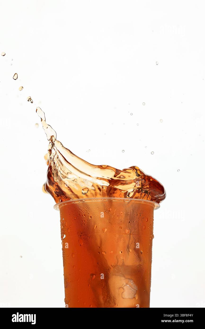 Low Angle Splash of Iced Tea on Plastic Cup Isolated on White ...