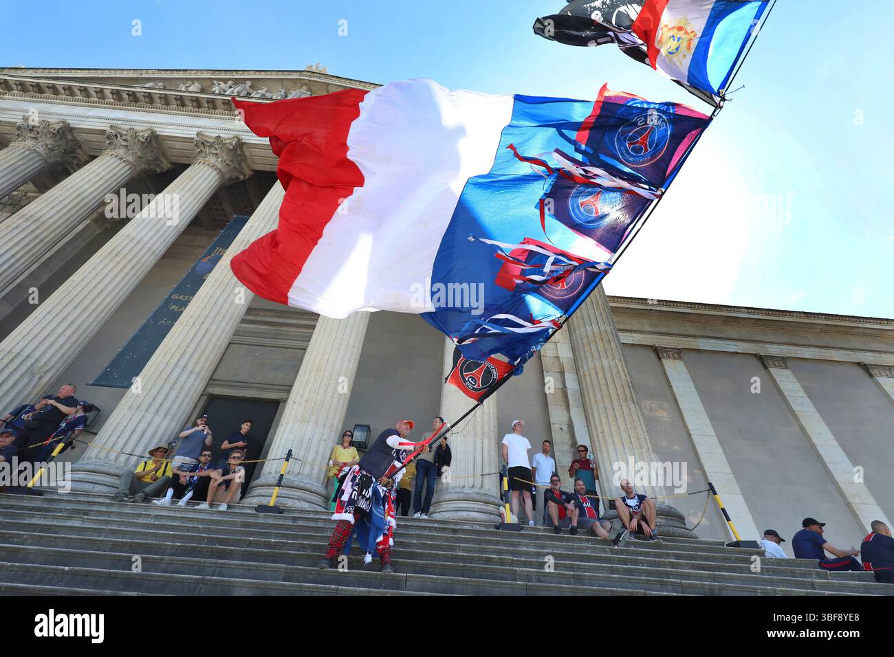 A PSG supporter waves giant flags ahead of the Champions League final ...