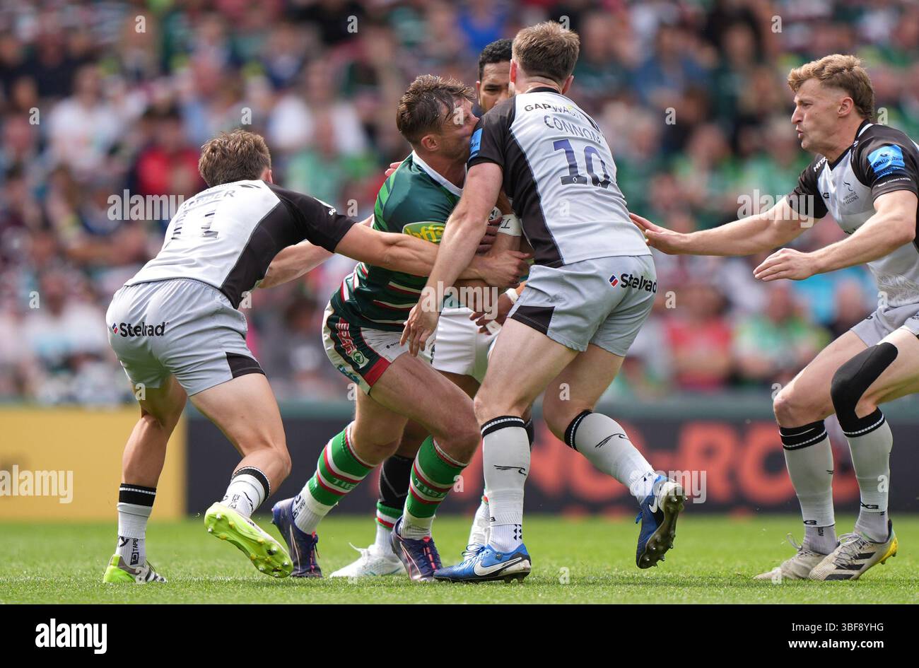 Leicester Tigers' Josh Bassett is tackled by Newcastle Falcons' Max ...