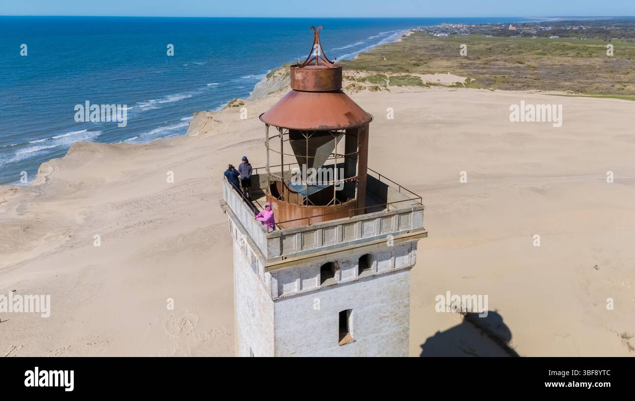 Visitors stand atop an iconic lighthouse, enjoying breathtaking views ...
