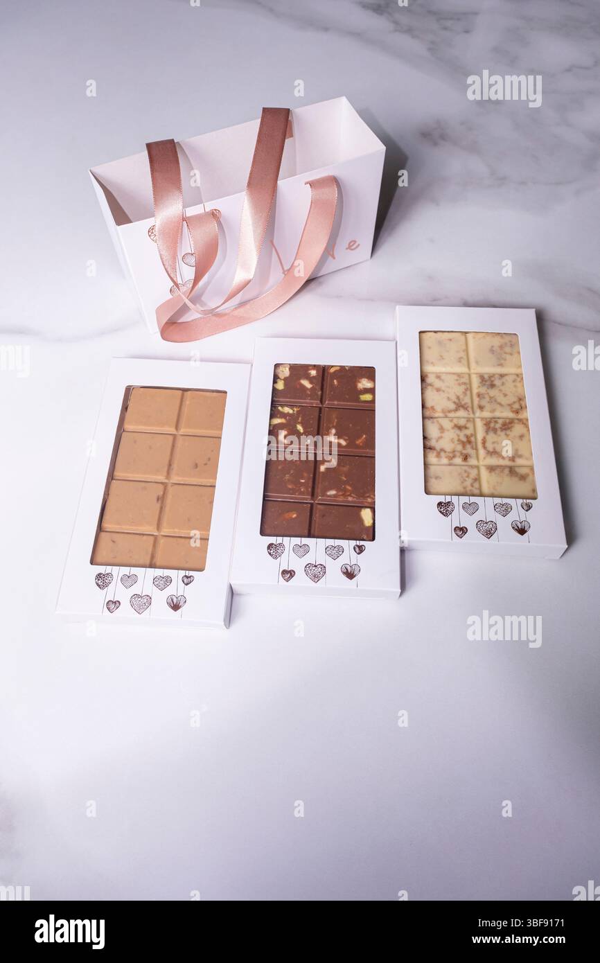 Three assorted chocolate bars next to a bag vertical Stock Photo - Alamy