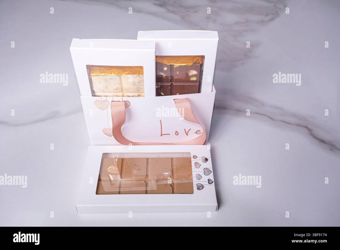 Three assorted chocolate bars gift wrapped Stock Photo - Alamy