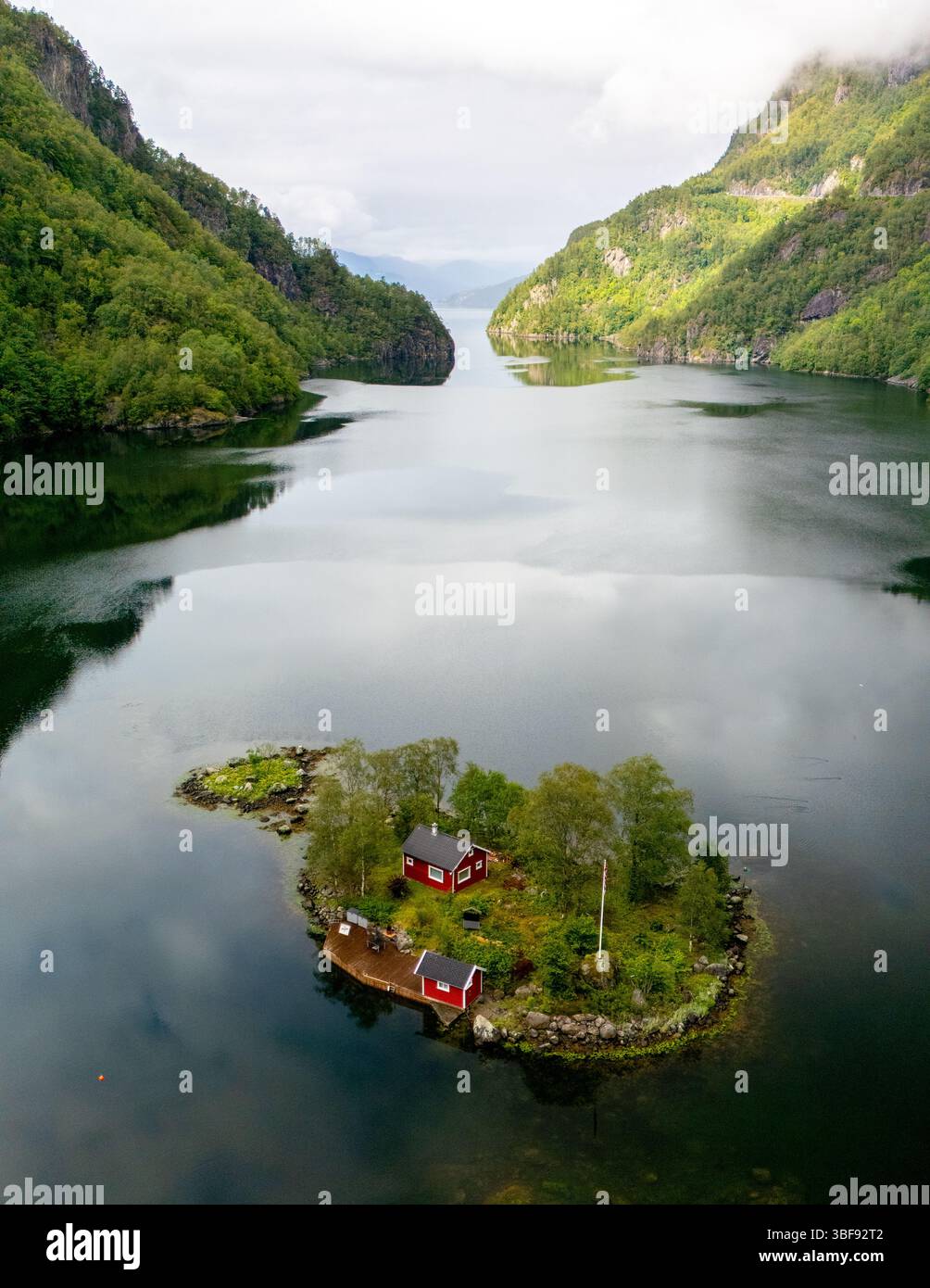 A picturesque island features a charming red cabin nestled among lush ...