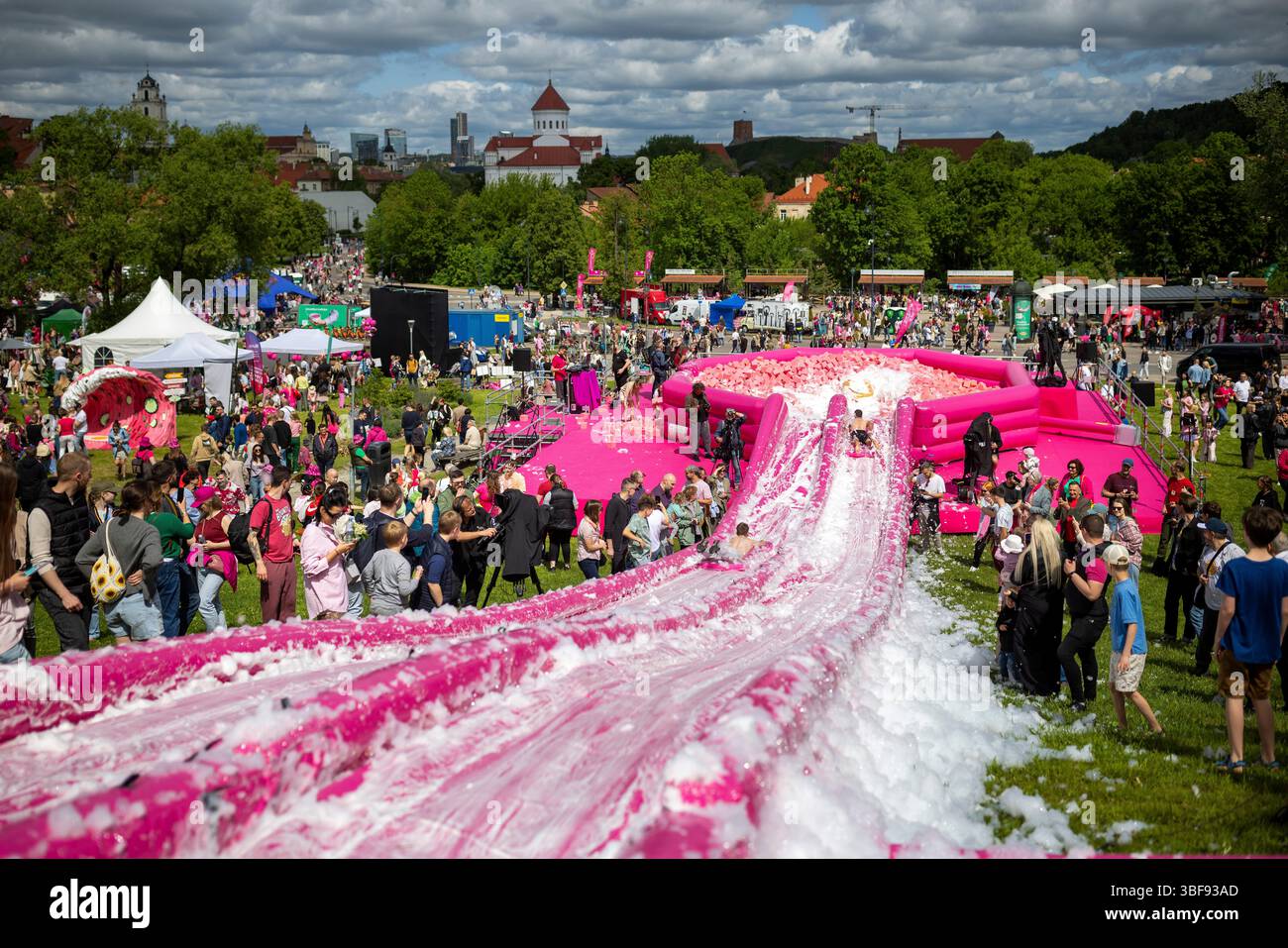 Visitors slide down a water slide into a giant soup bowl during the ...