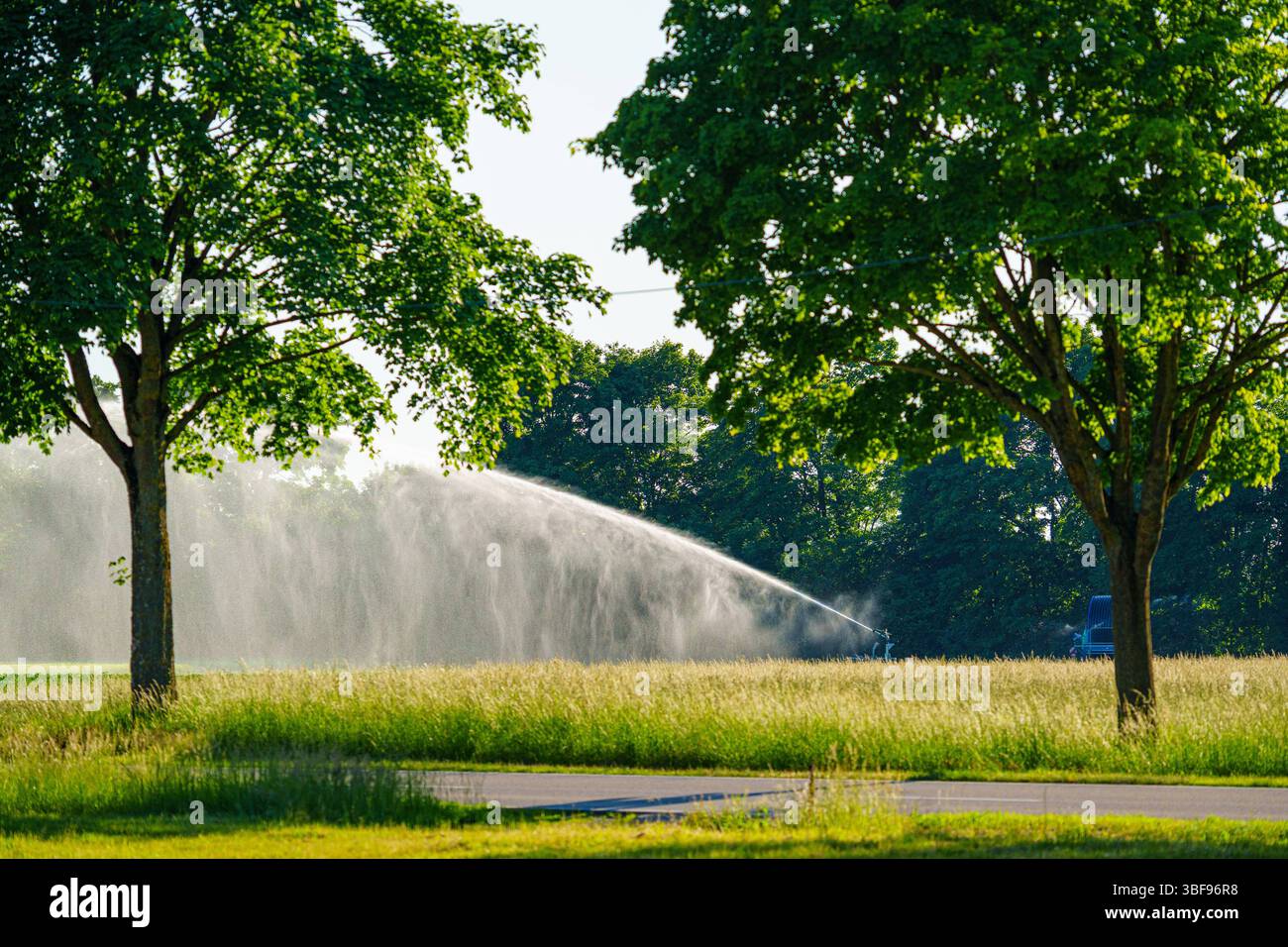 Oberding, Bavaria, Germany - 30 May 2025: A mobile sprinkler irrigates ...