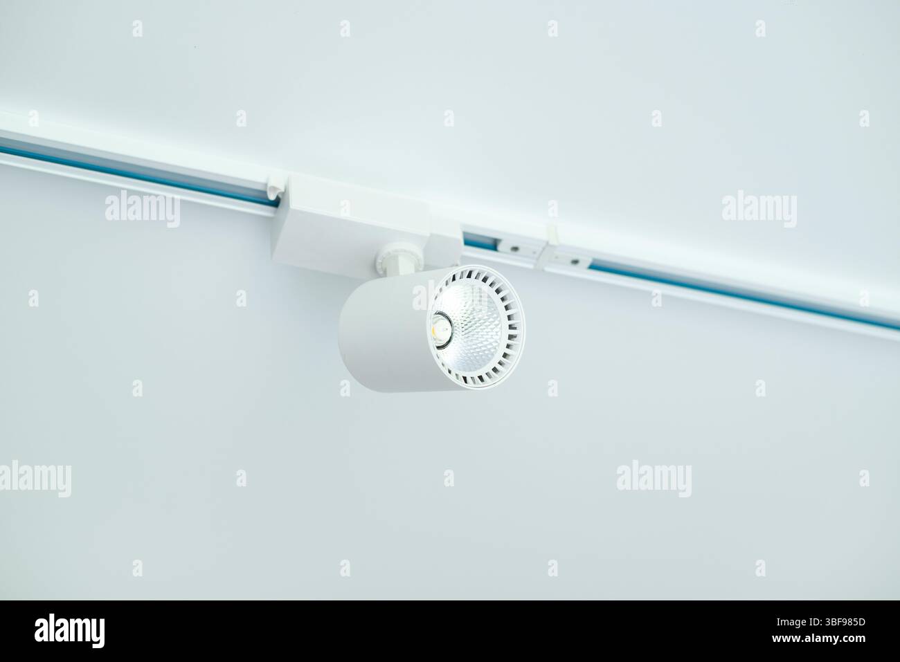 Modern white LED track light fixture mounted on ceiling rail ...