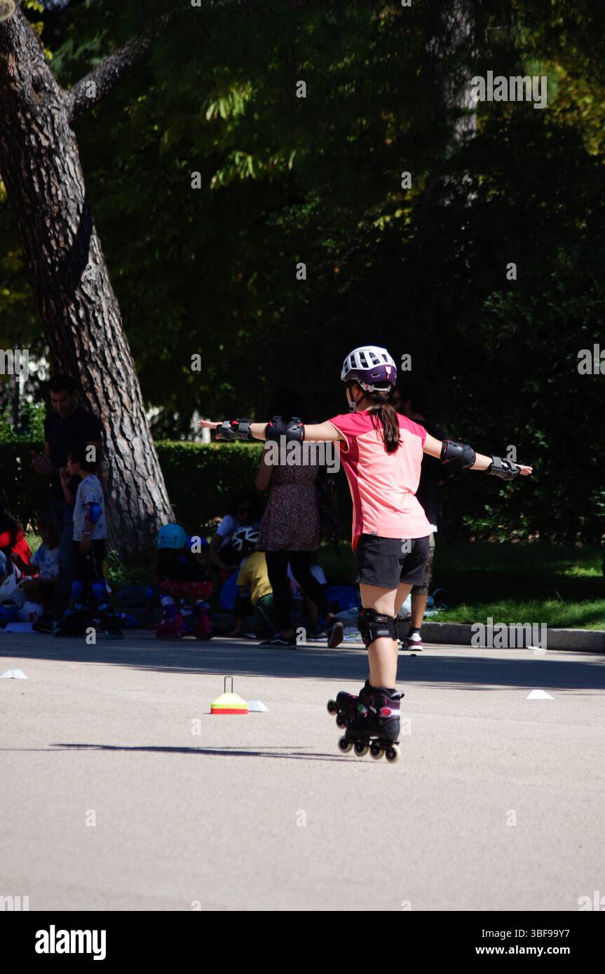 Youth practicing inline skating in a park, wearing a helmet, el-bow ...