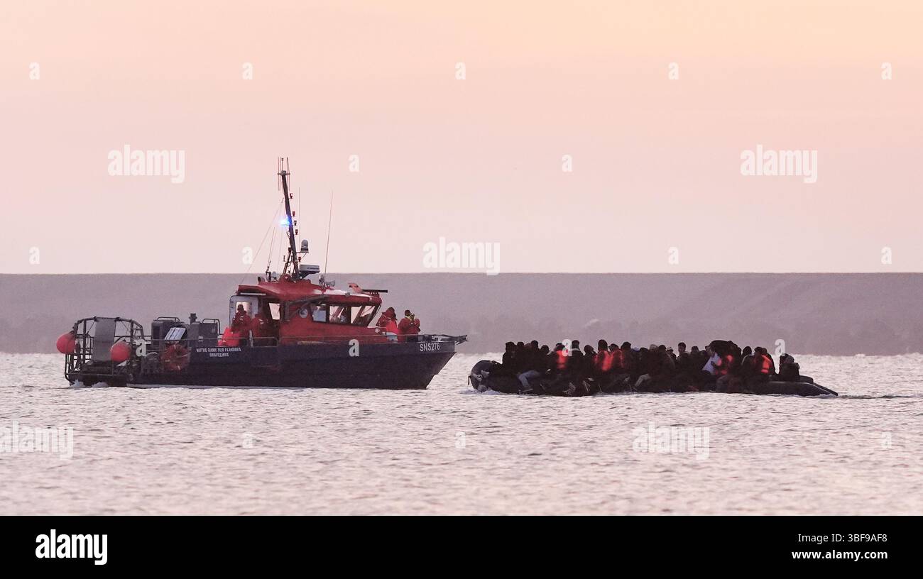 French authorities escort people thought to be migrants onboard a small ...