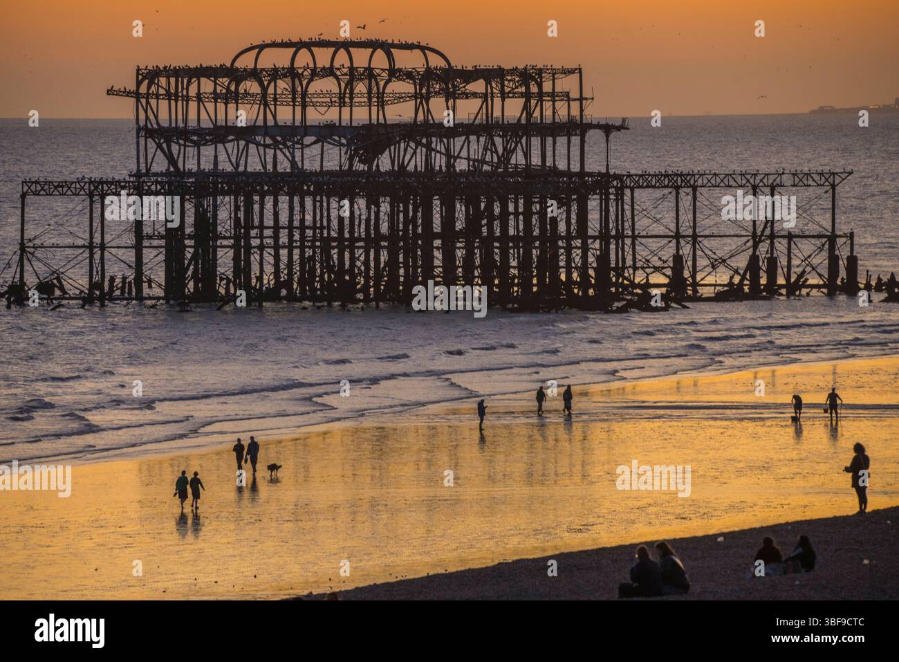 Brighton's derelict West Pier and adjacent beach at low tide and sunset ...