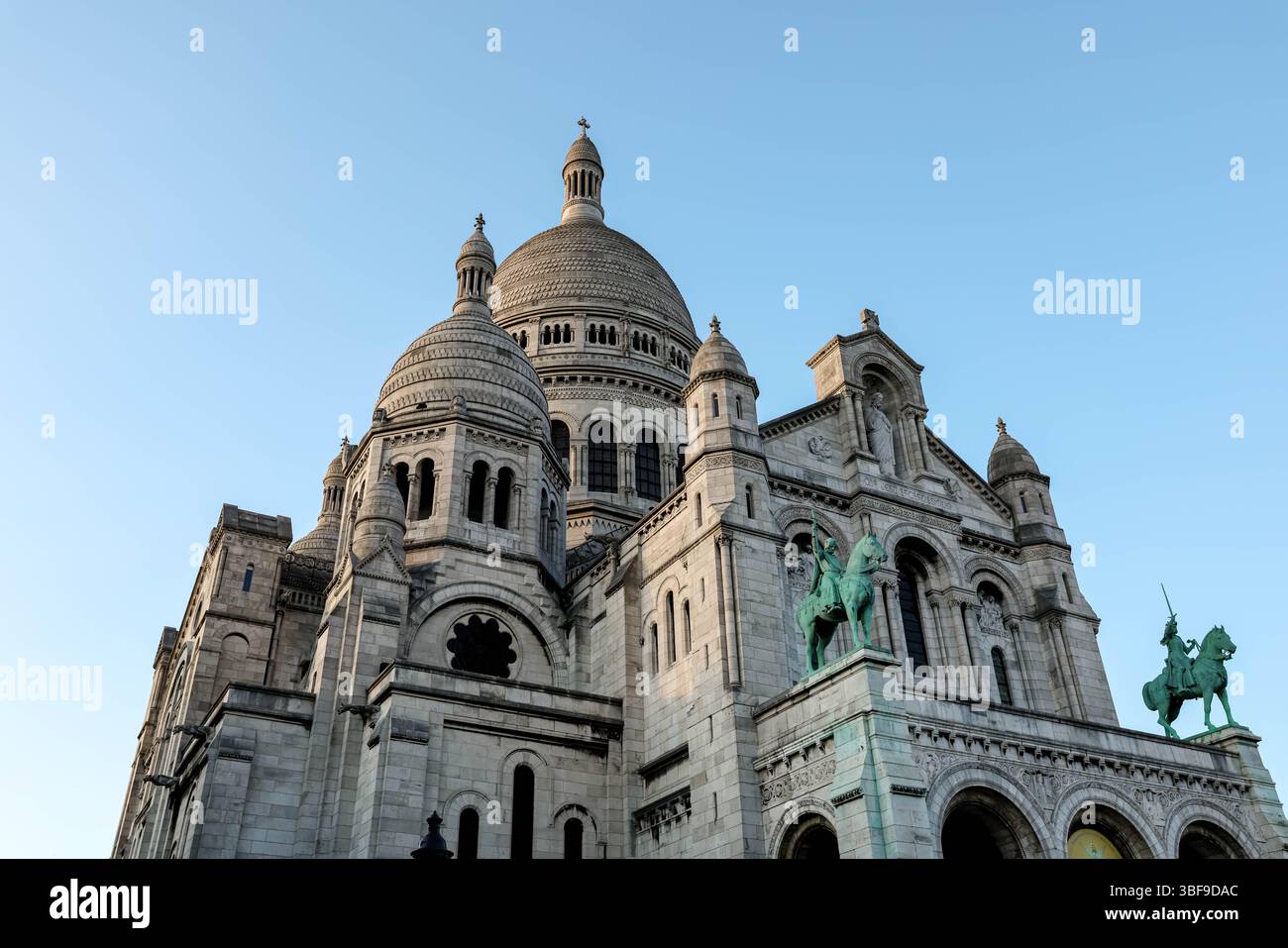 A low-angle view of the facade of Sacré-Cœur Basilica, showing the main ...