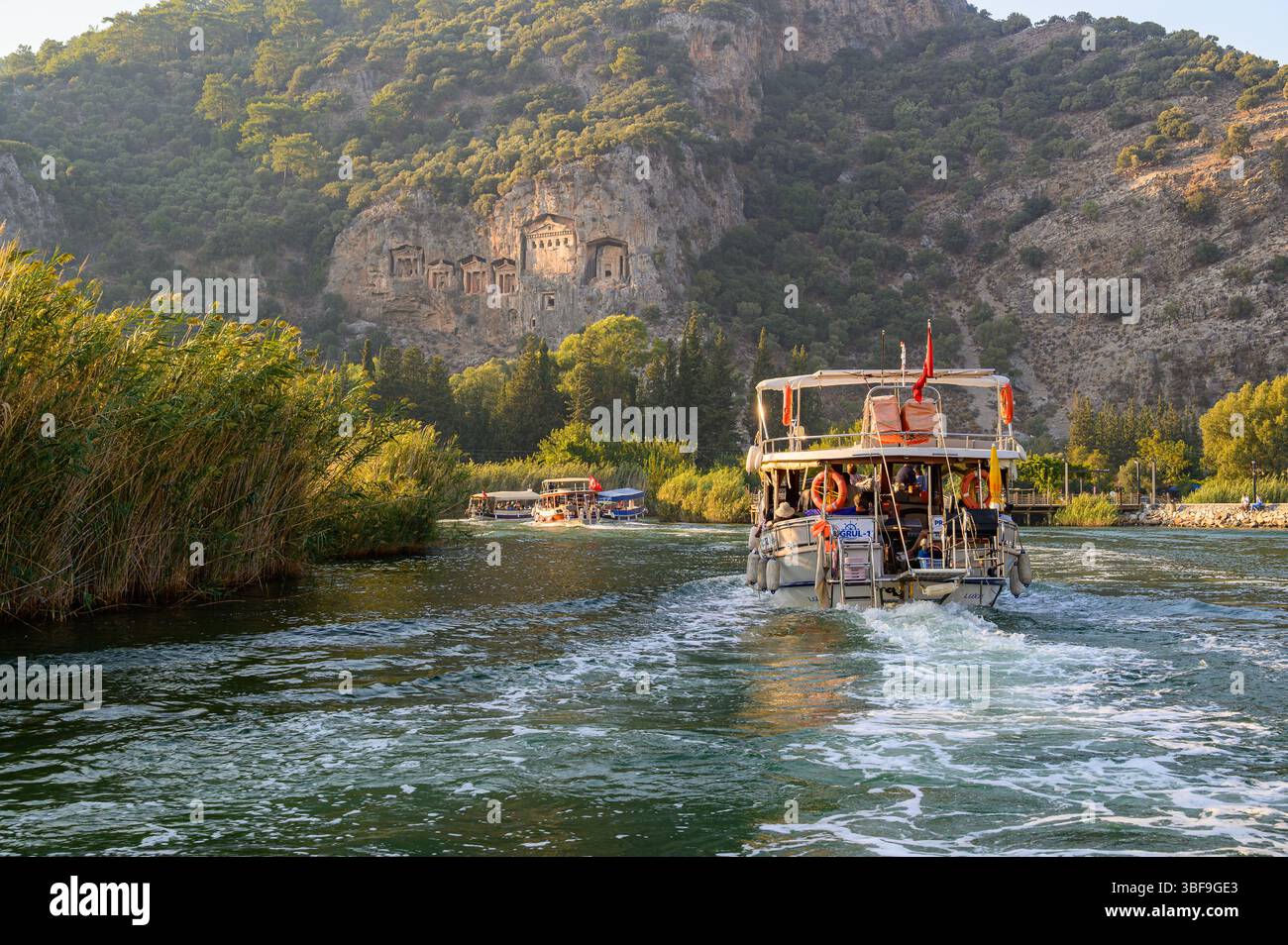 Tour boats on the Dalyan River pass beneath ancient Lycian rock tombs ...
