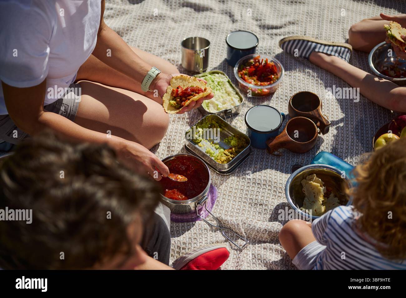 Parents and children are enjoying a serene outdoor picnic, sharing ...