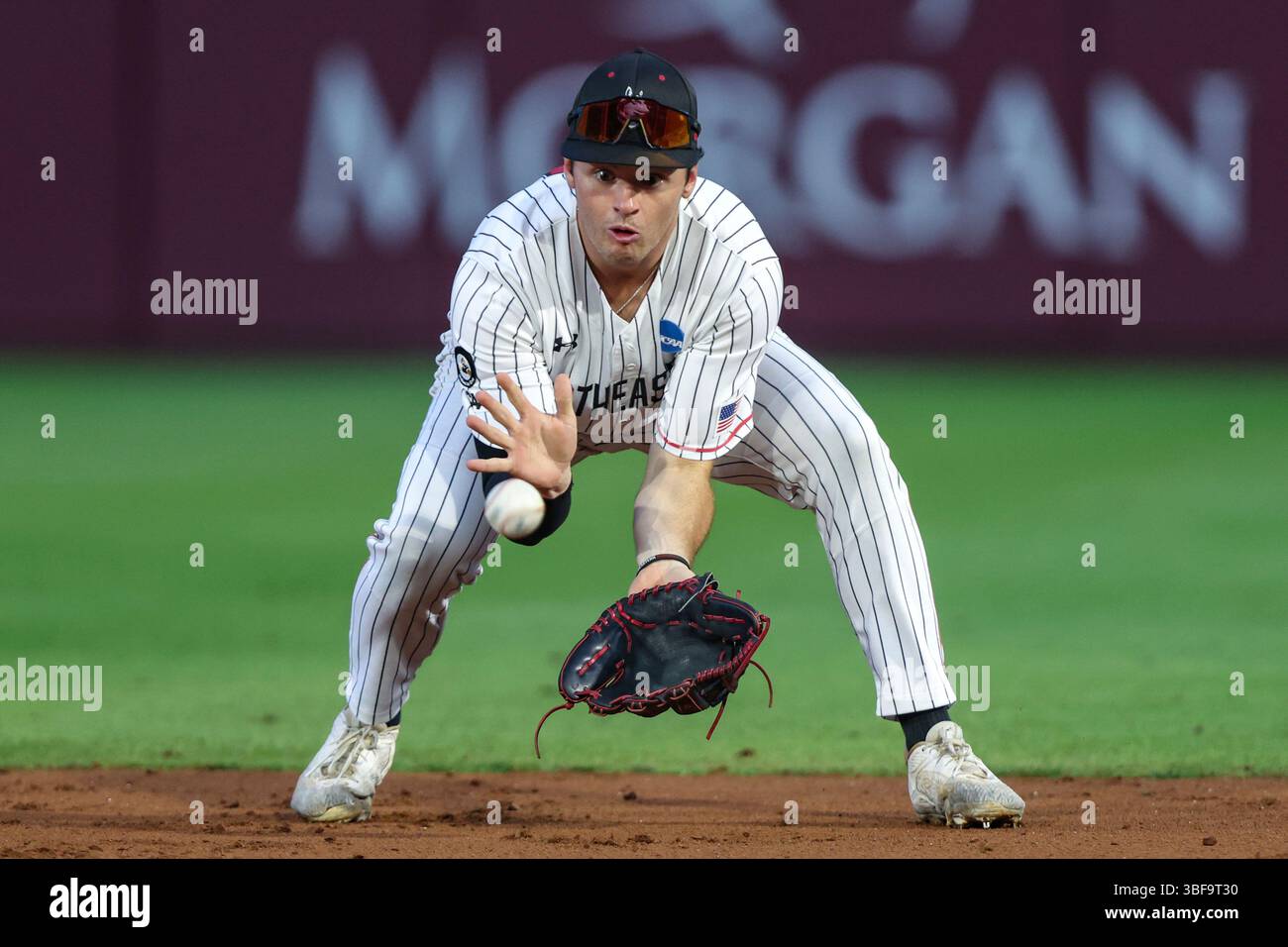 Northeastern infielder Chris Walsh (18) warms up before an NCAA ...