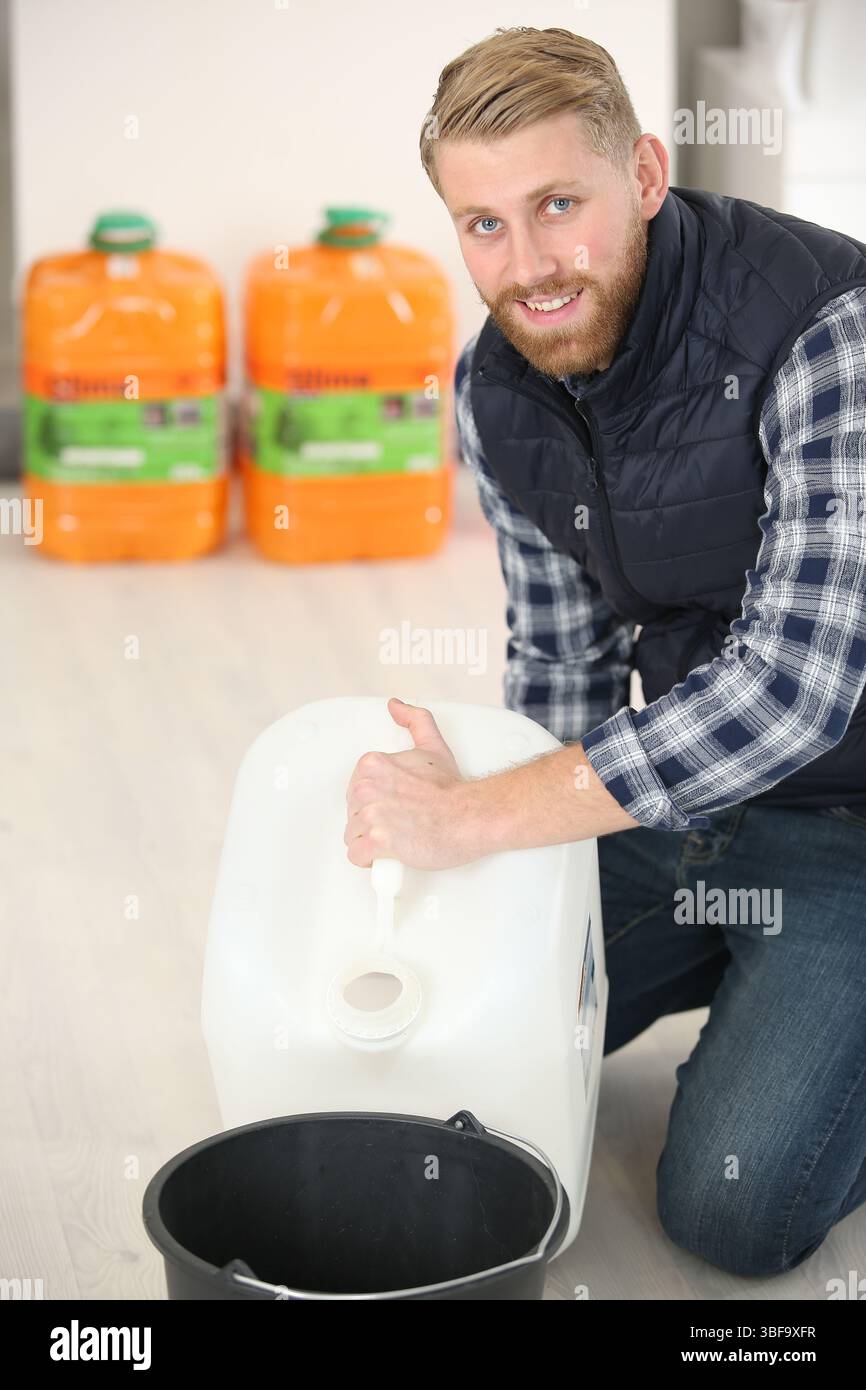 man pouring industrial product from container into bucket Stock Photo ...