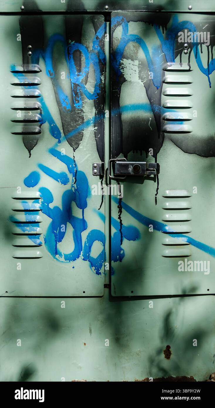 Green louvered utility box covered in shadow and paint Stock Photo - Alamy