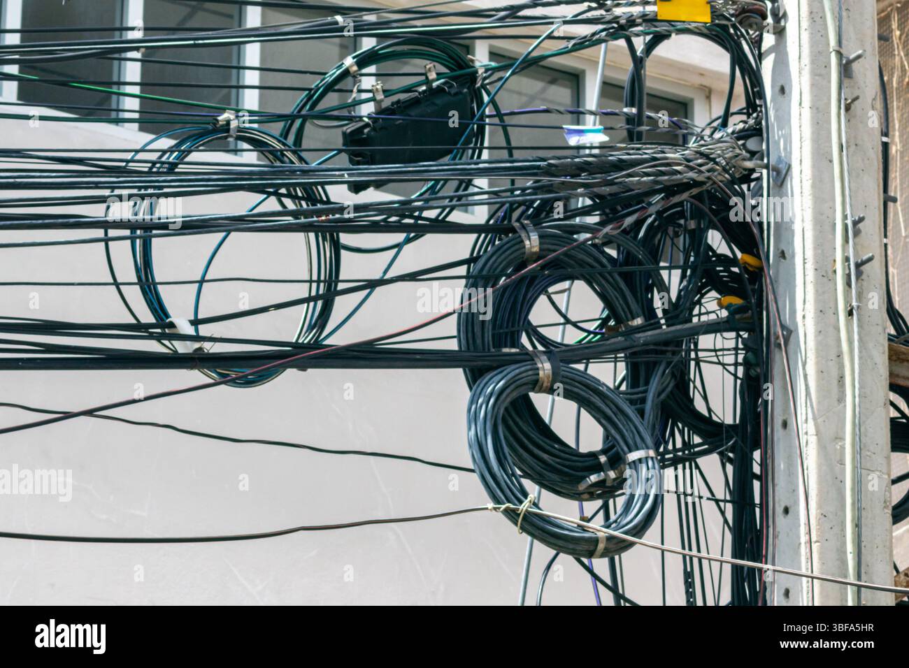 A complex arrangement of power cables and wires across an urban setting ...