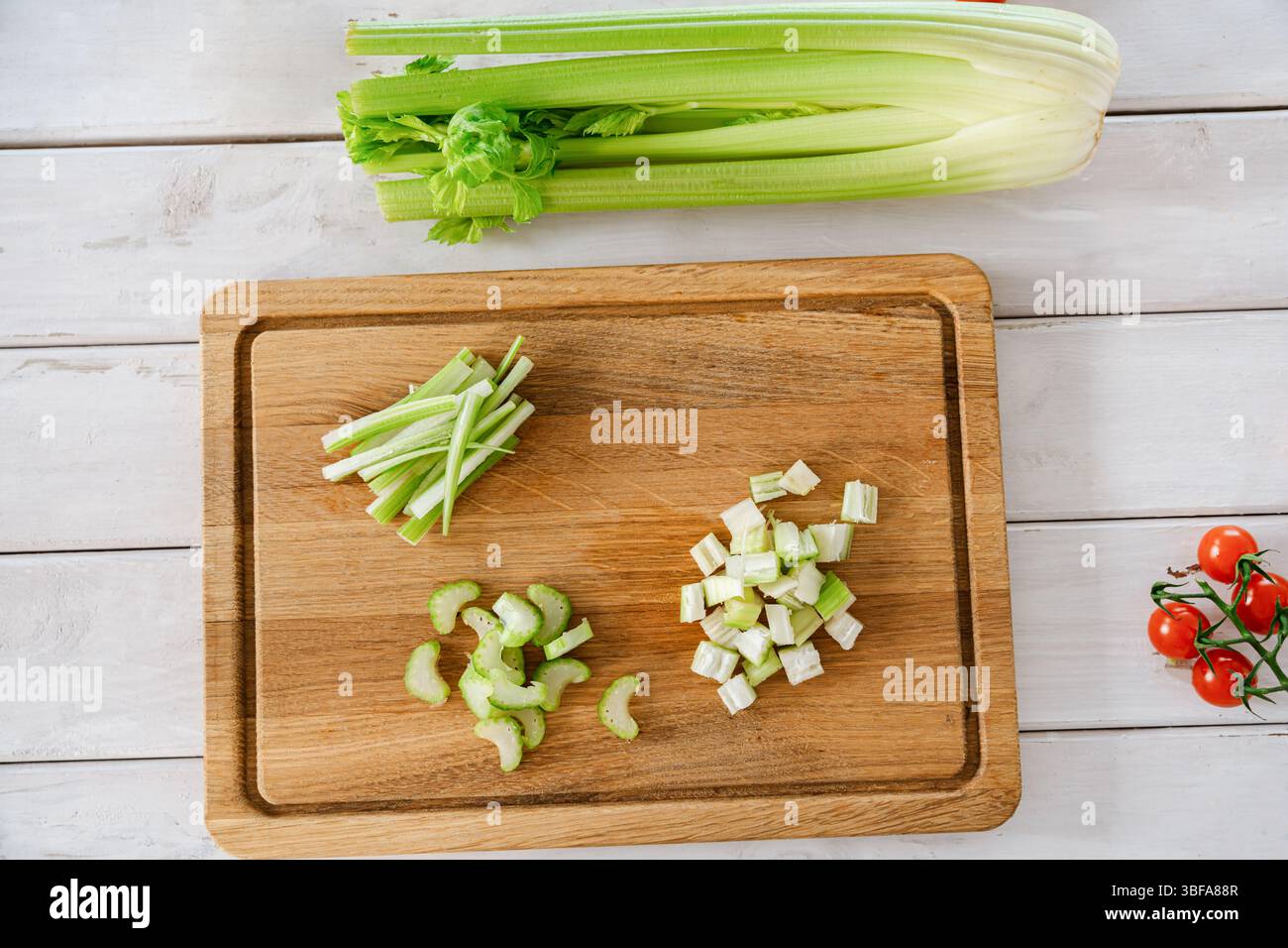 Celery stalks sliced in multiple ways on a wooden board, top view, for ...