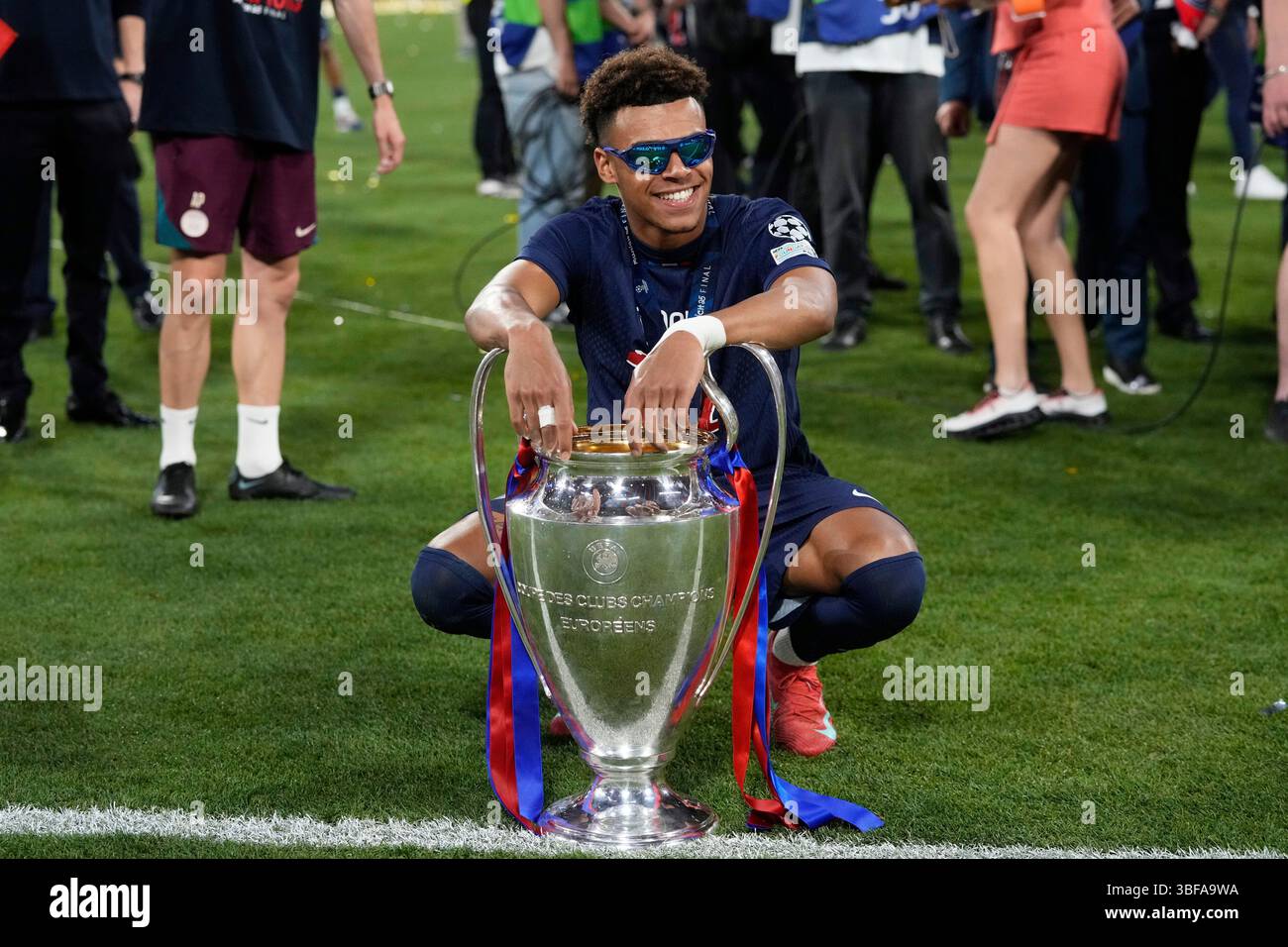PSG's Desire Doue poses with the trophy after winning the Champions ...