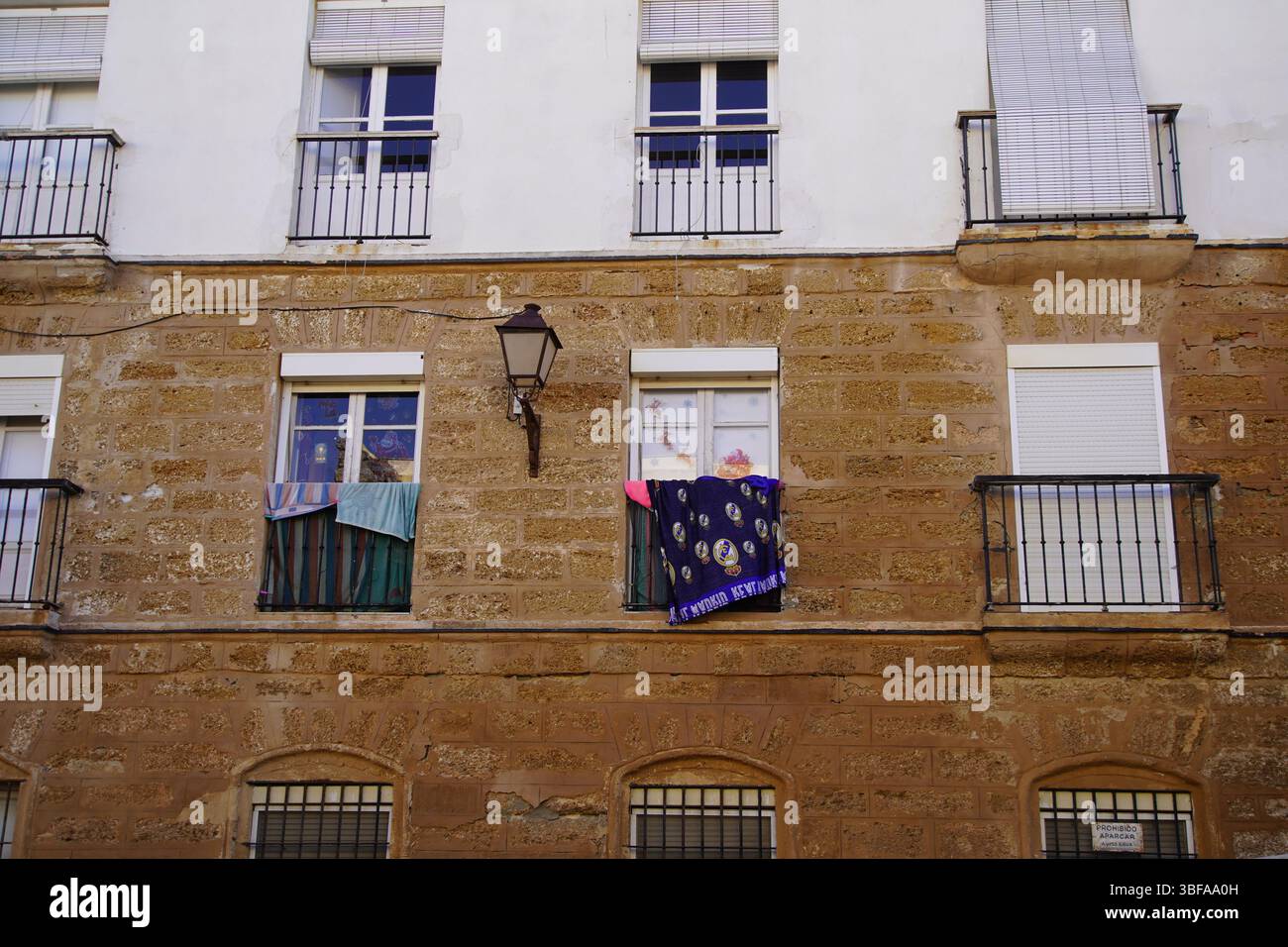 View of window balconies with railings showing towels hanging to dry ...