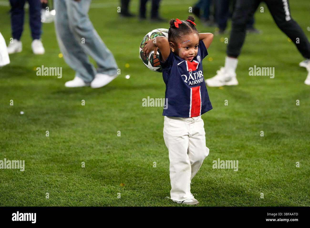 A child wearing a shirt with the number of PSG's Ousmane Dembele walks ...
