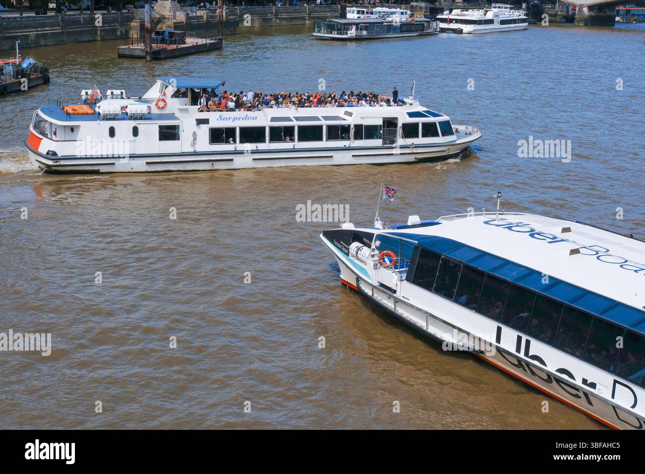 A tourist cruise boat and Uber Boat river ferry manoeuvre close to ...